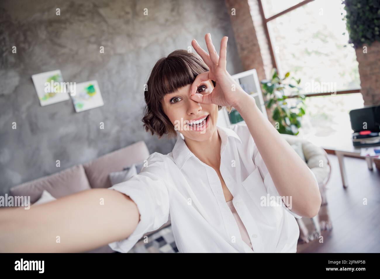Photo of cheerful positive amazed woman make finger okay sign eye look ...