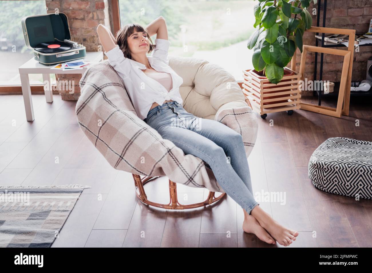 Full length photo of attractive young happy woman hands behind head sit ...