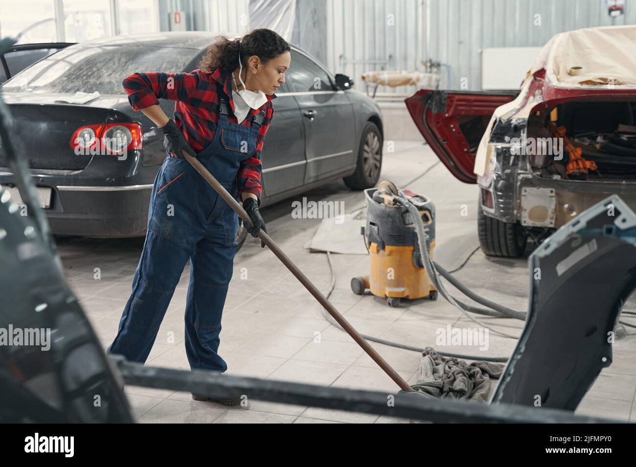 Concentrated mechanic cleaning workplace after car coloring Stock Photo ...
