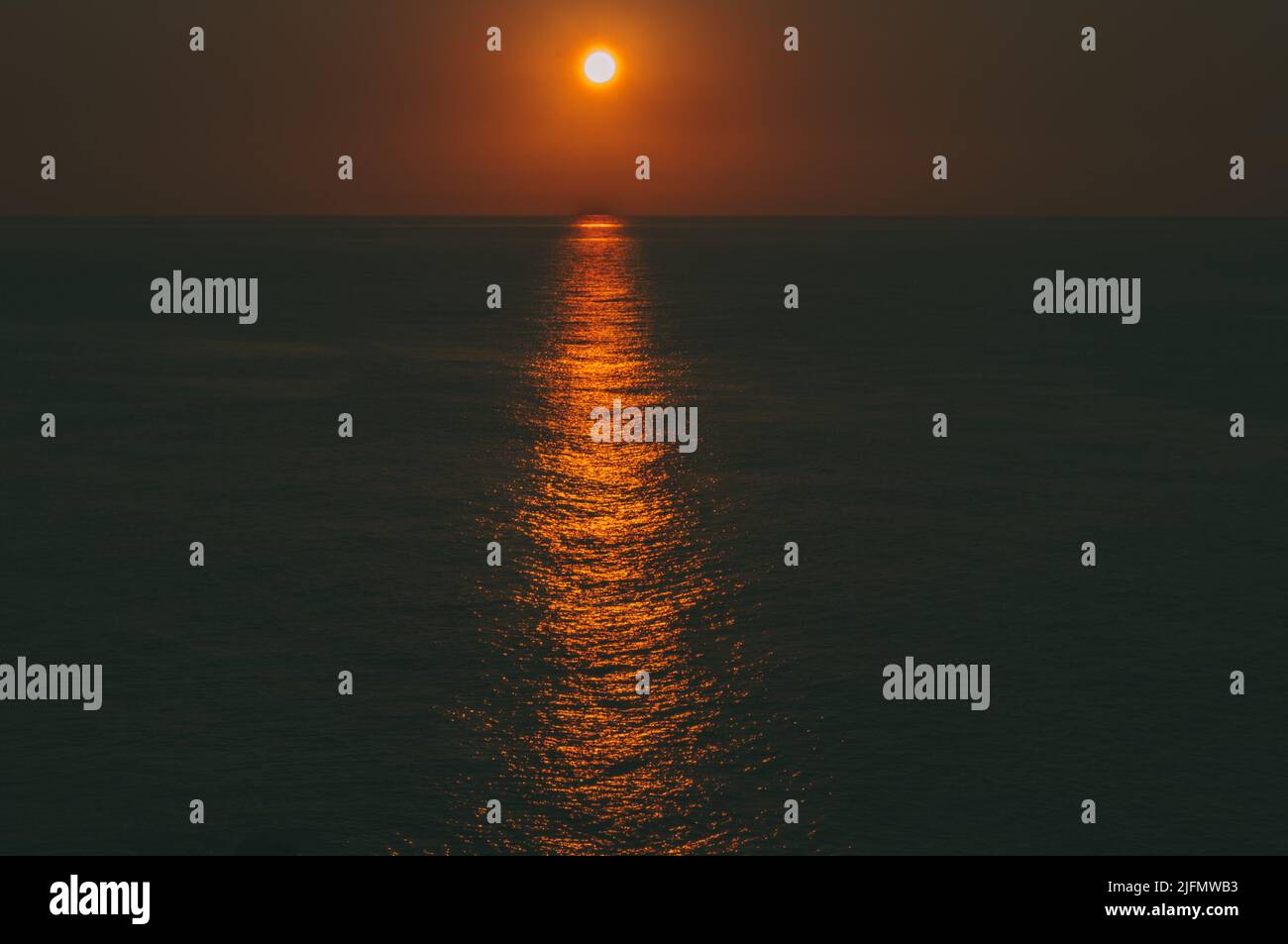 Amazing sunset on the sea horizon. Calm, surface Stock Photo - Alamy
