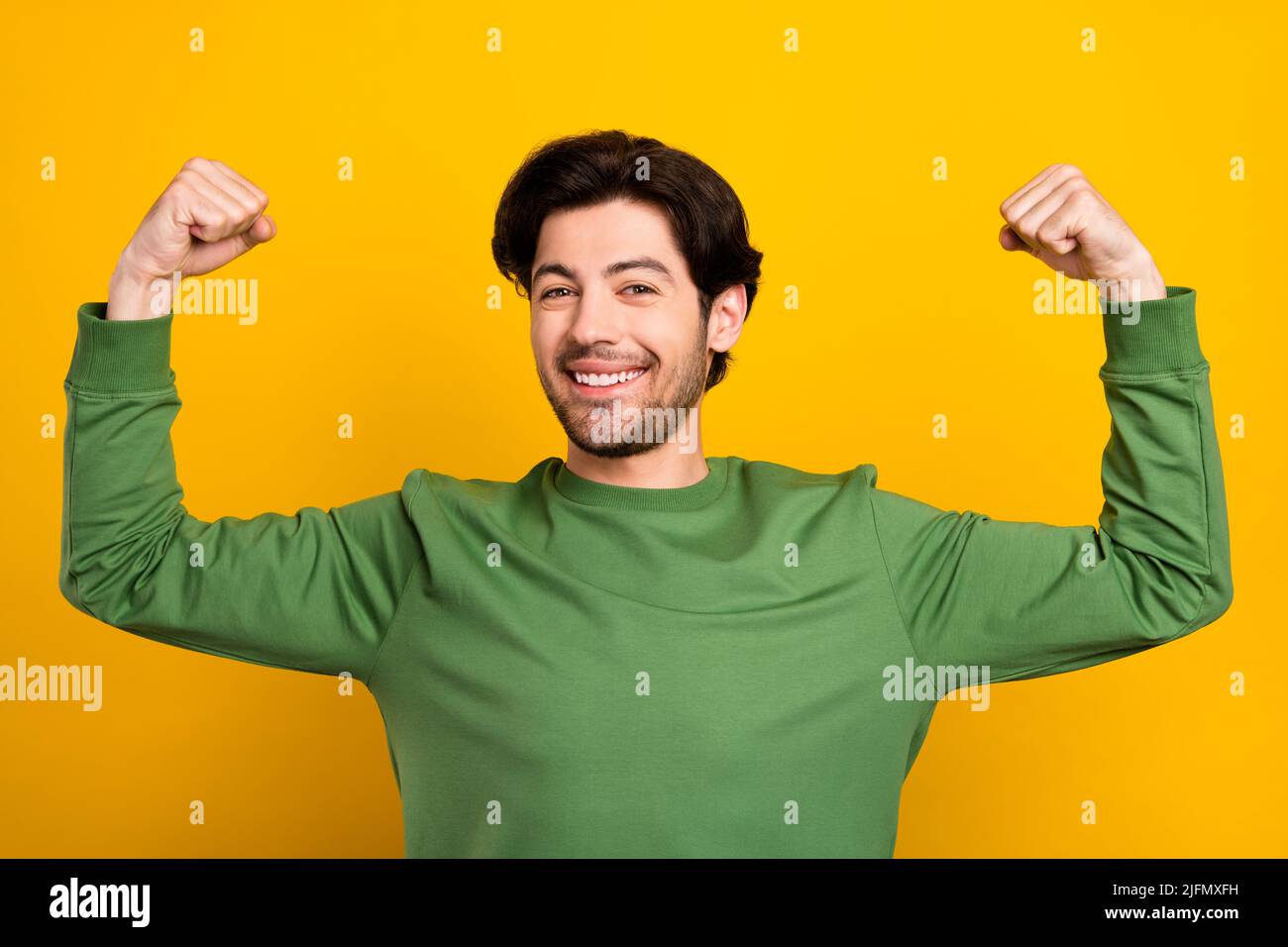 Photo of strong masculine virile guy show two biceps wear green sweater ...