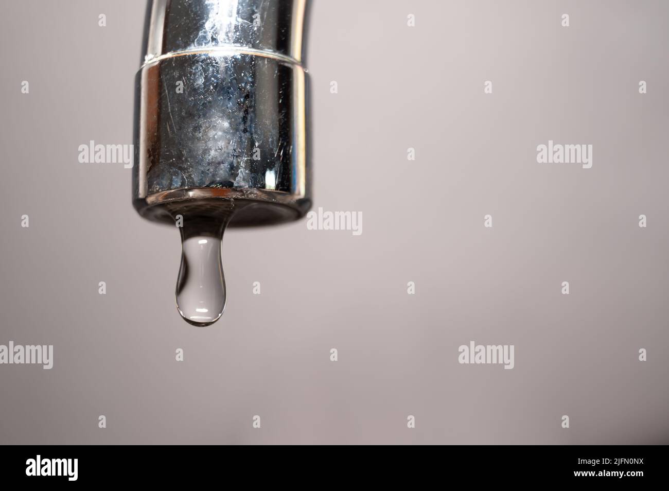 Tap from which drops of water flow. Drought, shortage, rationing and ...