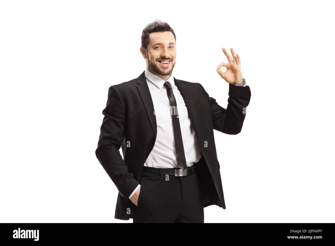 Young man wearing black suit and gesturing ok sign isolated on white ...