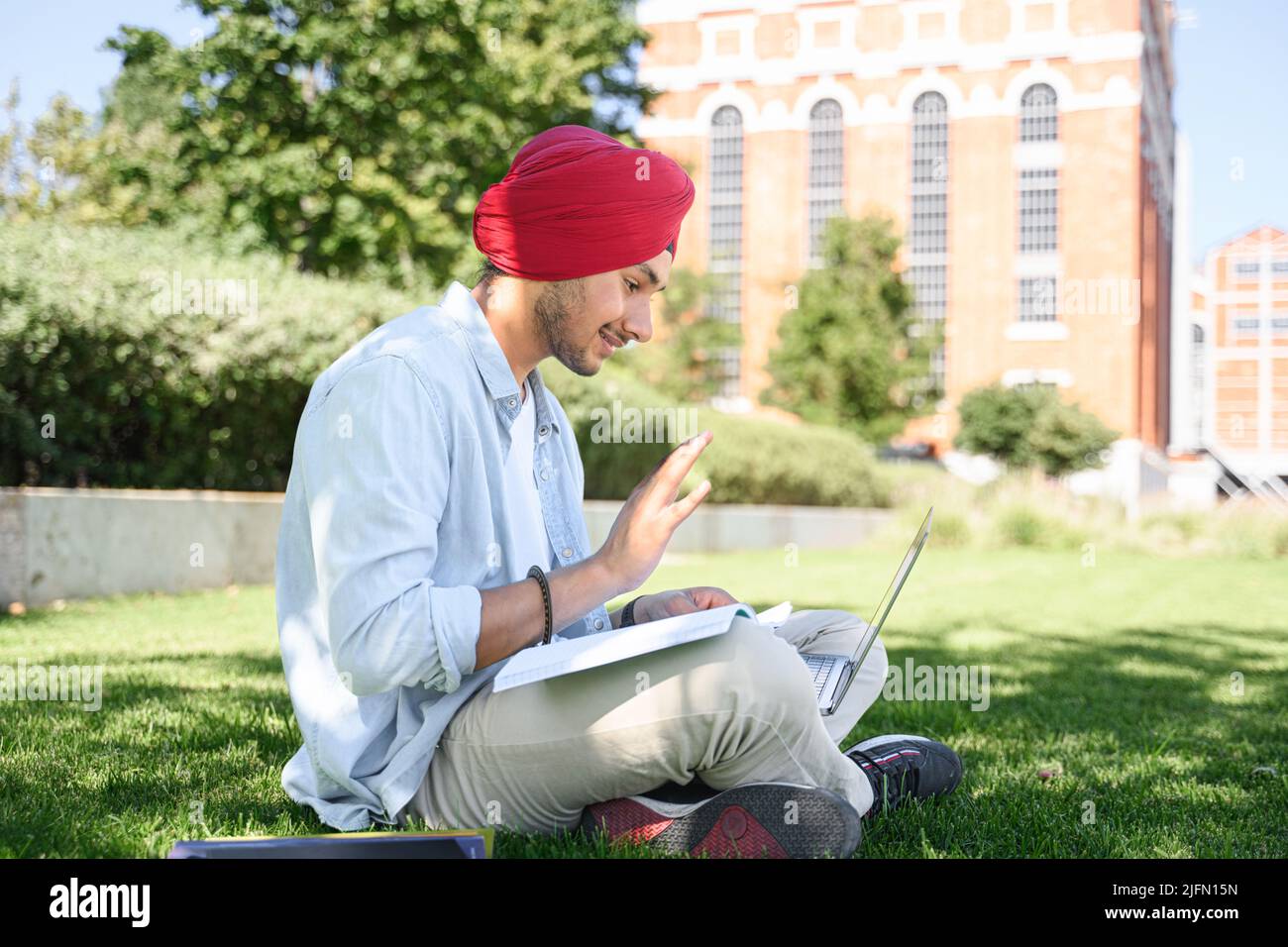 Male Indian student wearing red traditional headwrap turban pheta using ...