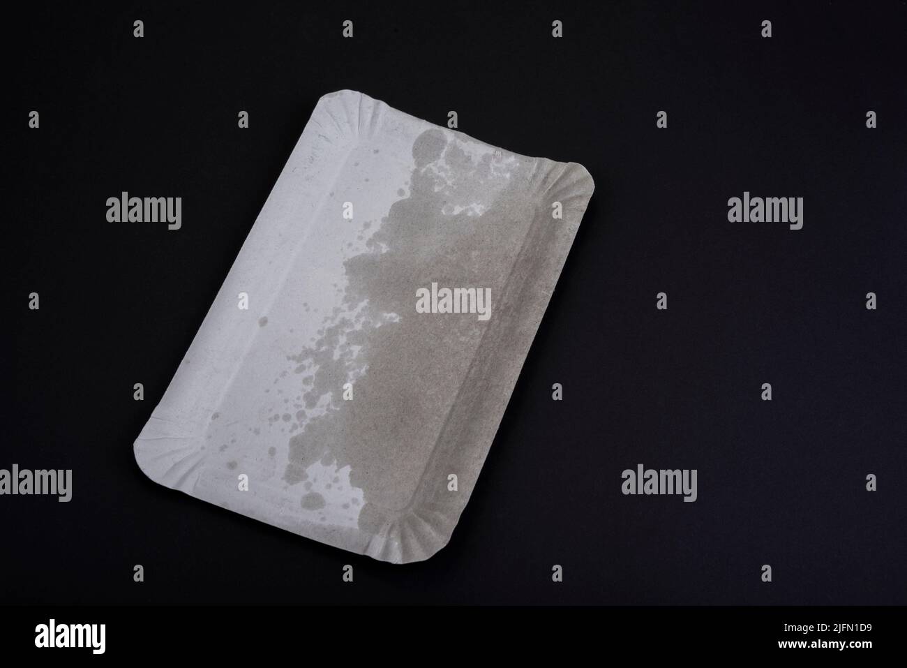 Empty grease paper plate on a black background Stock Photo - Alamy