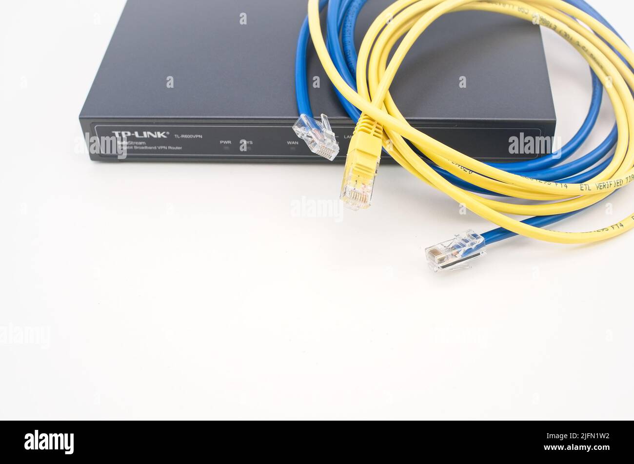 TP-LINK gigabit broadband network router with network cables on a white ...