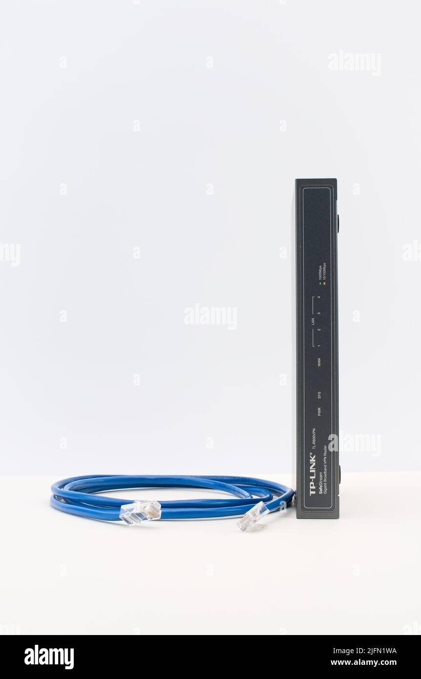 TP-LINK gigabit broadband network router with network cables on a white ...