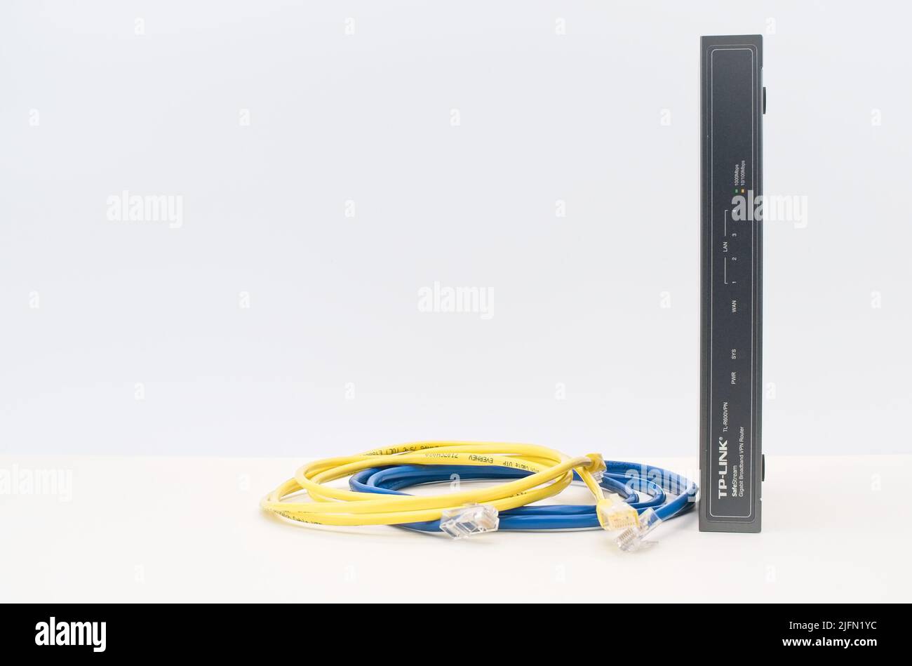 TP-LINK gigabit broadband network router with network cables on a white ...