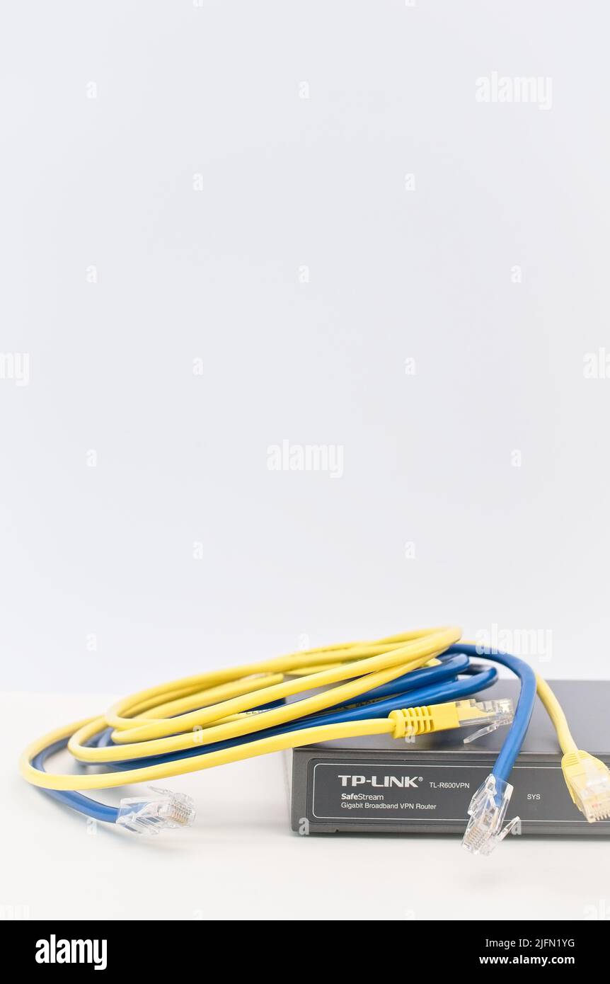 TP-LINK gigabit broadband network router with network cables on a white ...