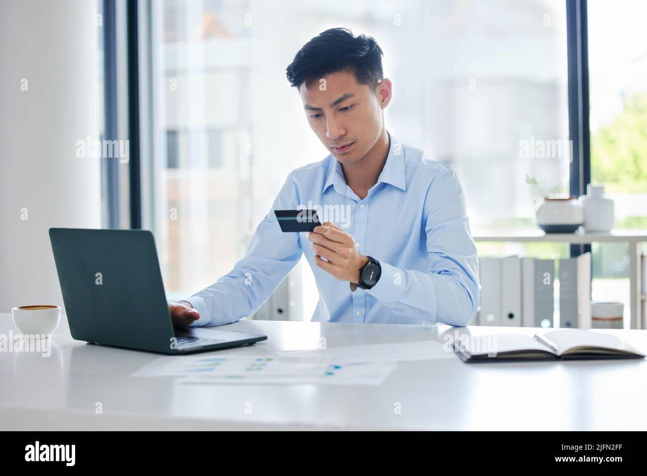 Closeup of one young asian businessman spending money online with a ...