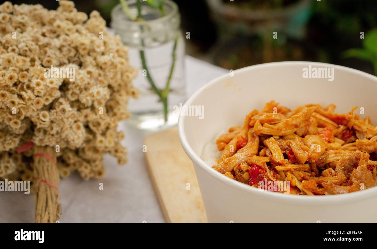 A selective shot of an Indian curry meal in a white bowl and dried ...