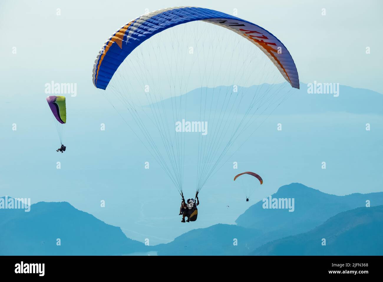 Paragliding in the sky. Paraglider tandem flying over the sea with ...