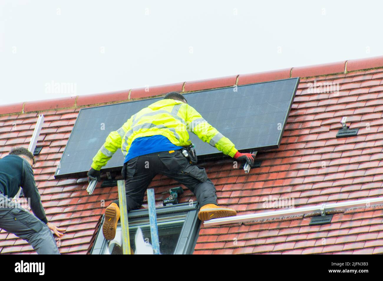Installing solar panels on roof Stock Photo - Alamy