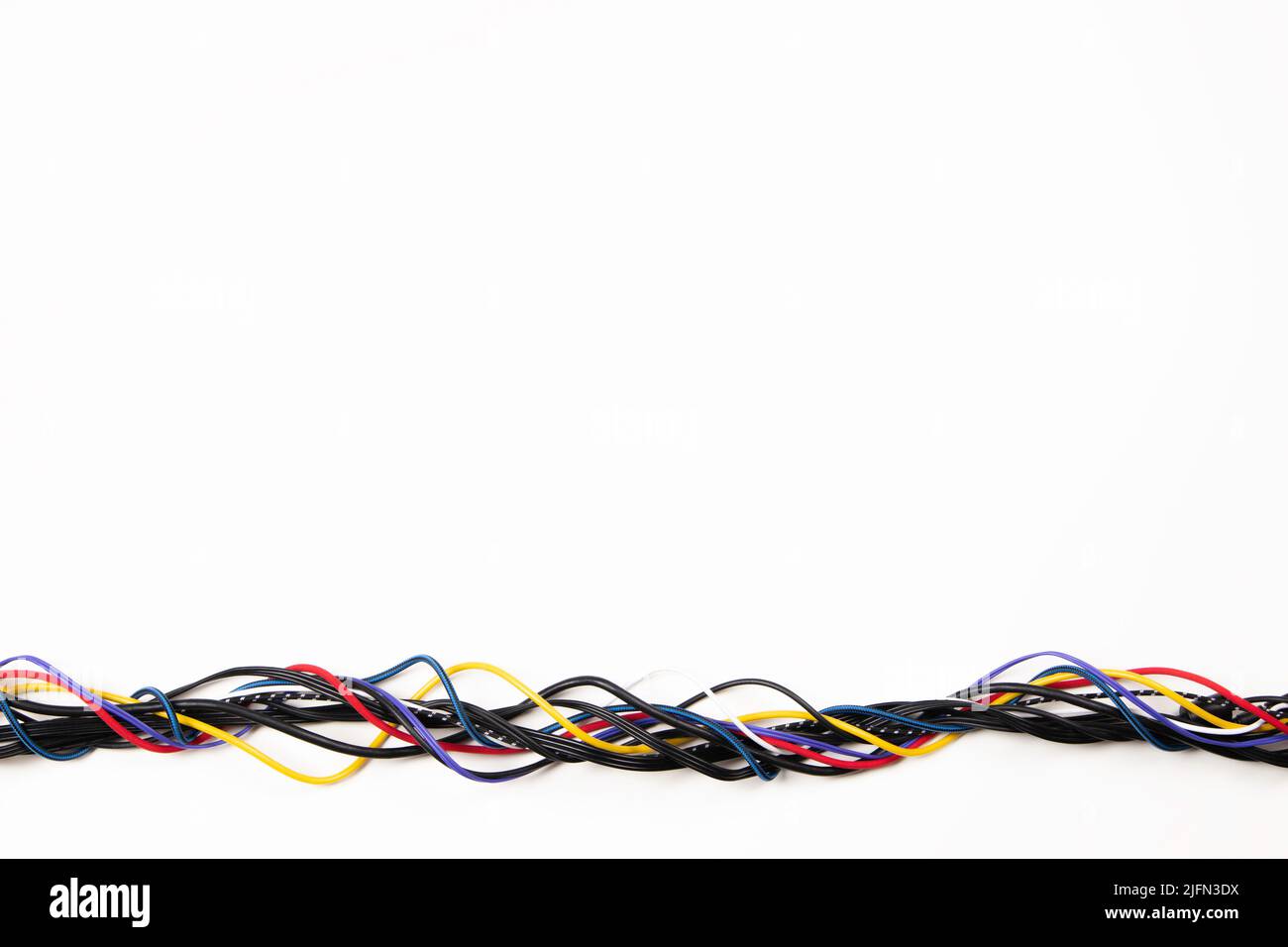 Many colorful electrical cord cables twist together into single frame ...