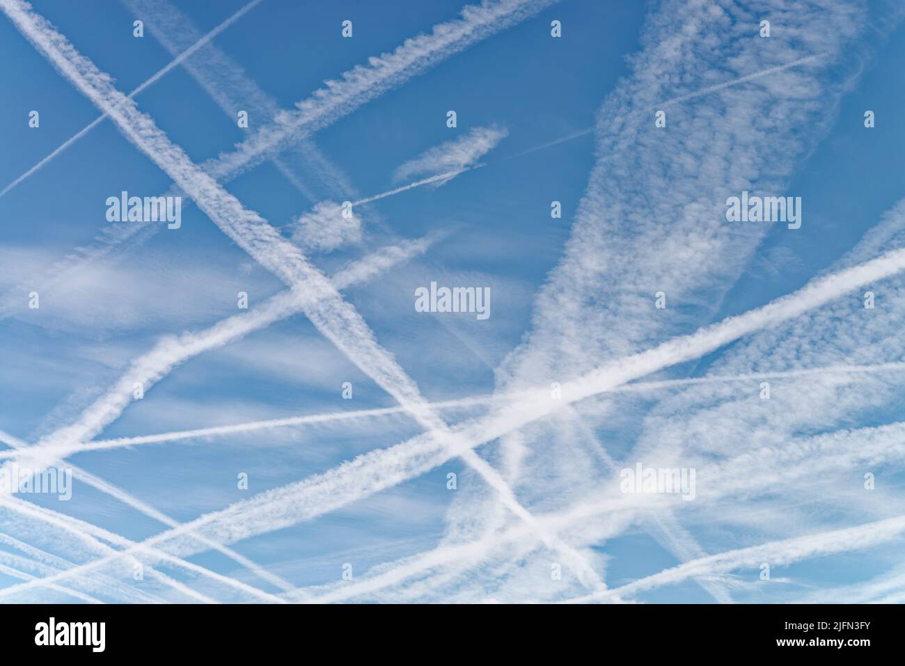 Numerous aircraft contrails against a blue sky Stock Photo - Alamy