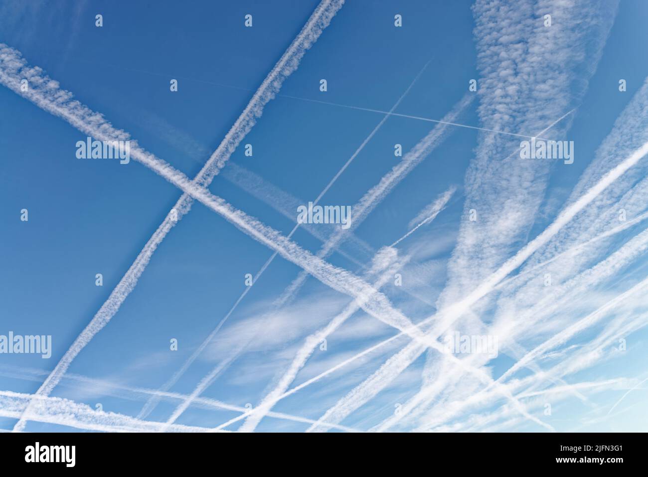 Numerous aircraft contrails against a blue sky Stock Photo - Alamy