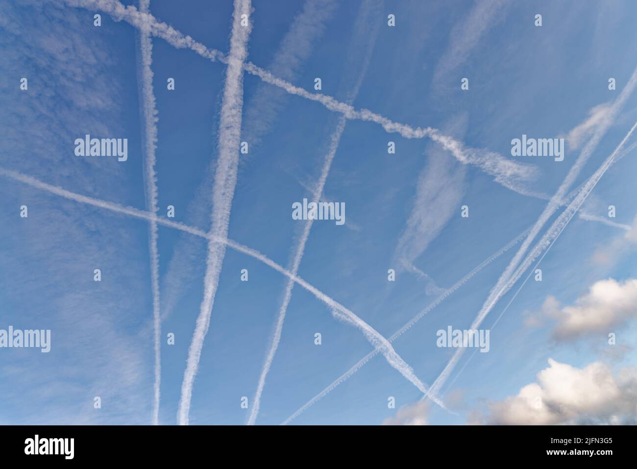 Numerous aircraft contrails against a blue sky Stock Photo - Alamy