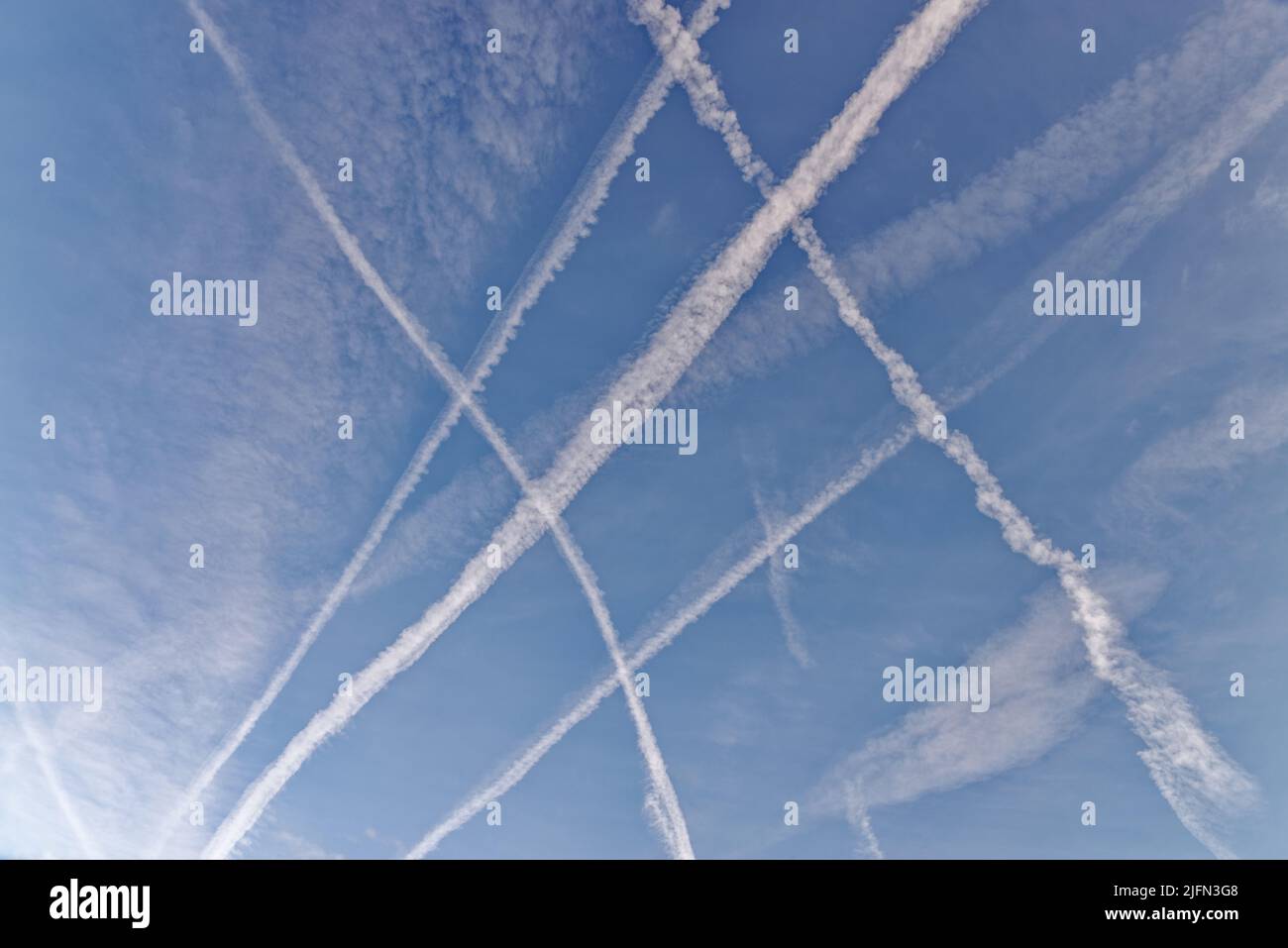 Numerous aircraft contrails against a blue sky Stock Photo - Alamy