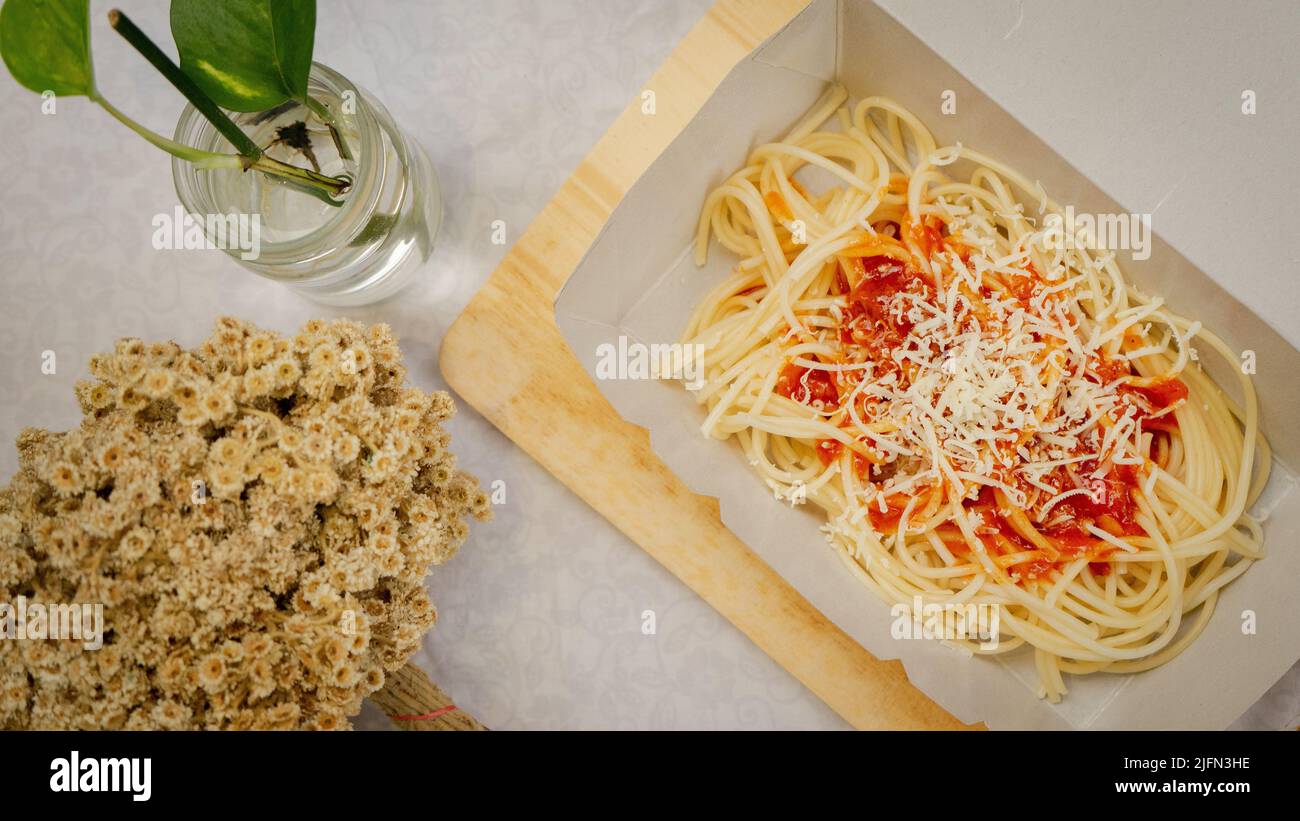 A top view of spaghetti with sauce and shredded cheese on top Stock ...