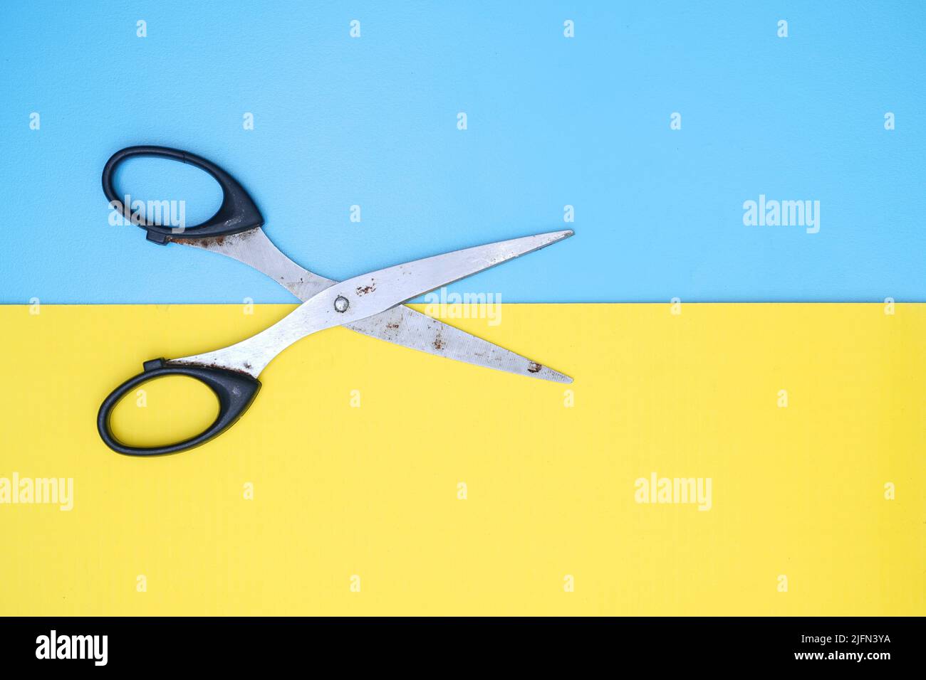 The scissors isolated on blue-yellow background with copy space Stock ...