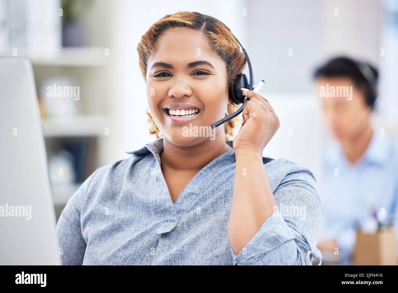Closeup of smiling mixed race female call center agent talking on ...