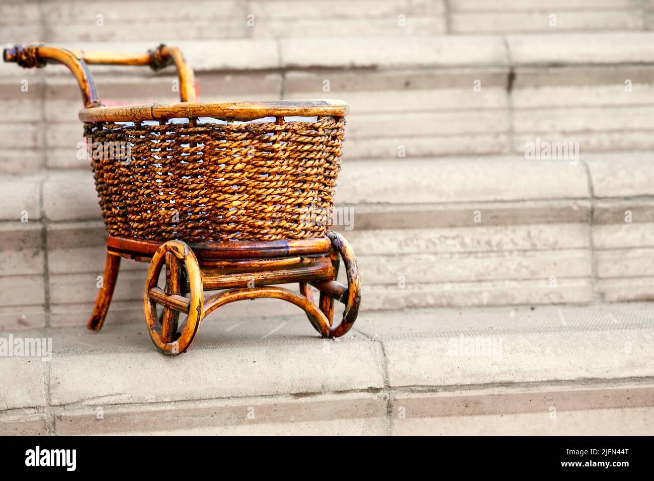 Wooden wicker brown cart on pale gray steps Stock Photo - Alamy