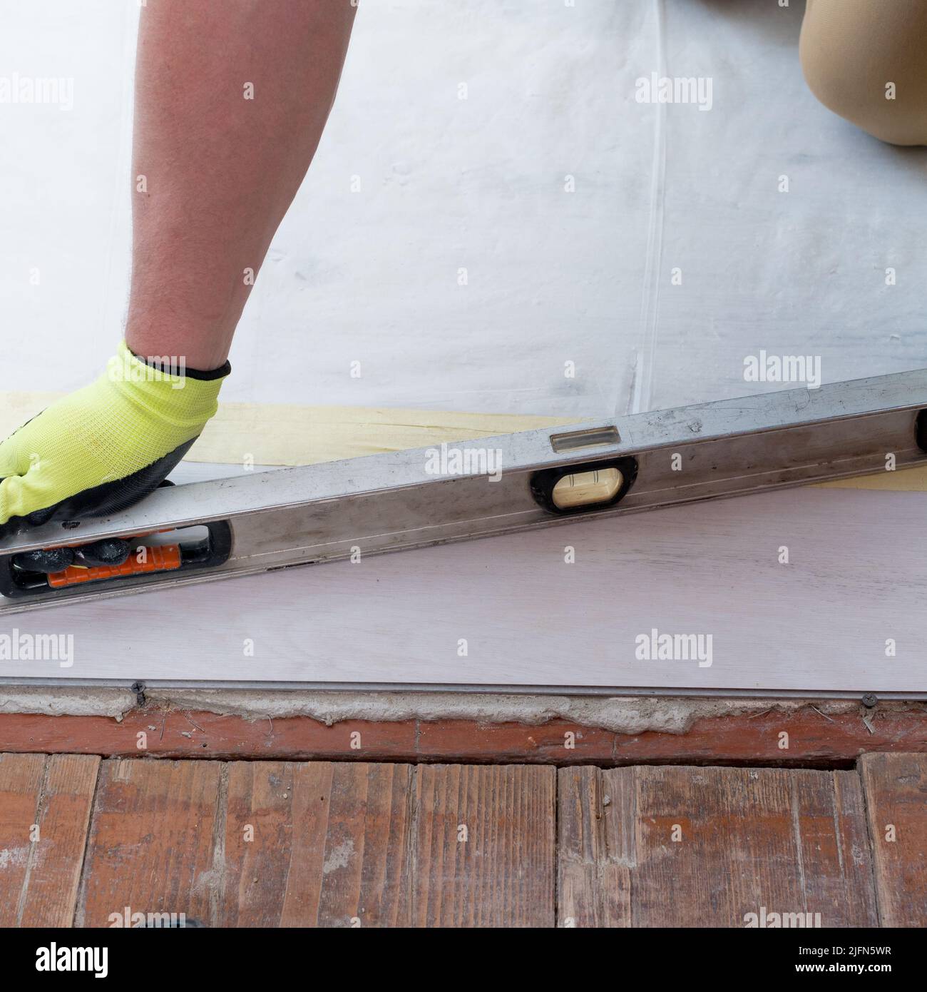 The master measures the level of the floor surface, repair and ...