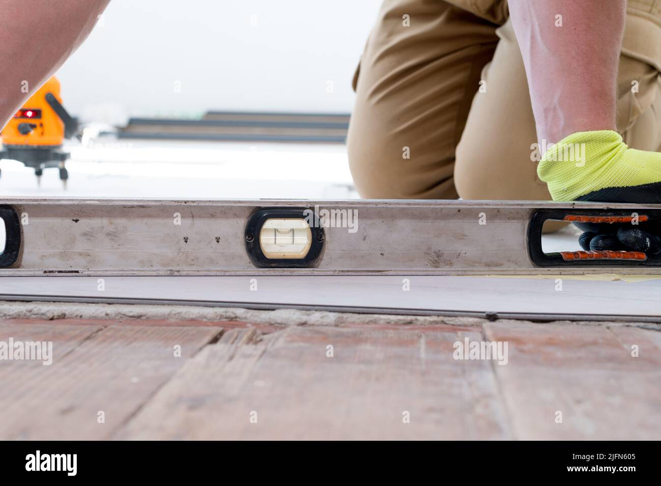 The master measures the level of the floor surface, repair and ...