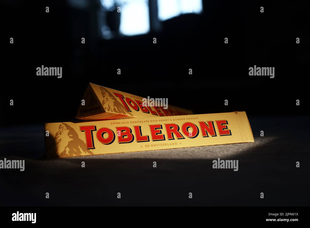 A Toblerone chocolate bar in the evening sun on a kitchen table in home ...
