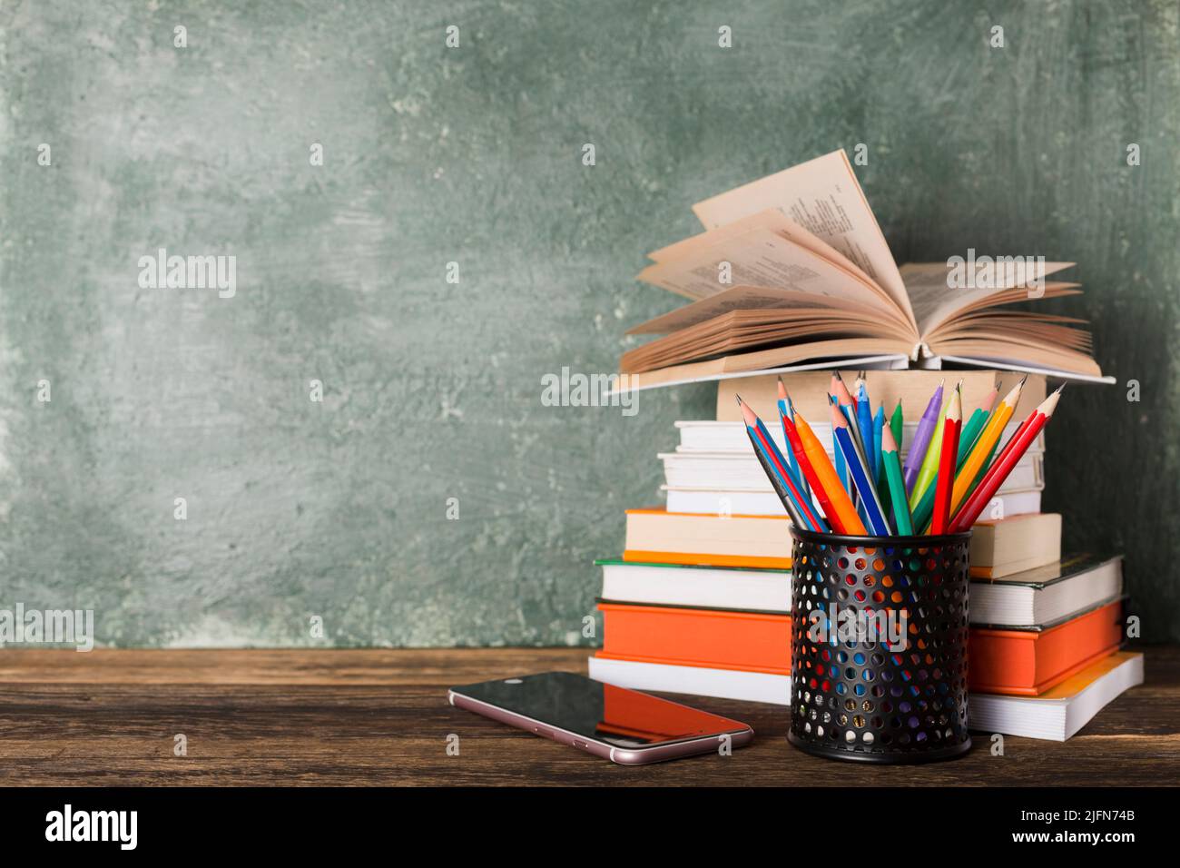 Stack of books and stationery on the background of the school board ...