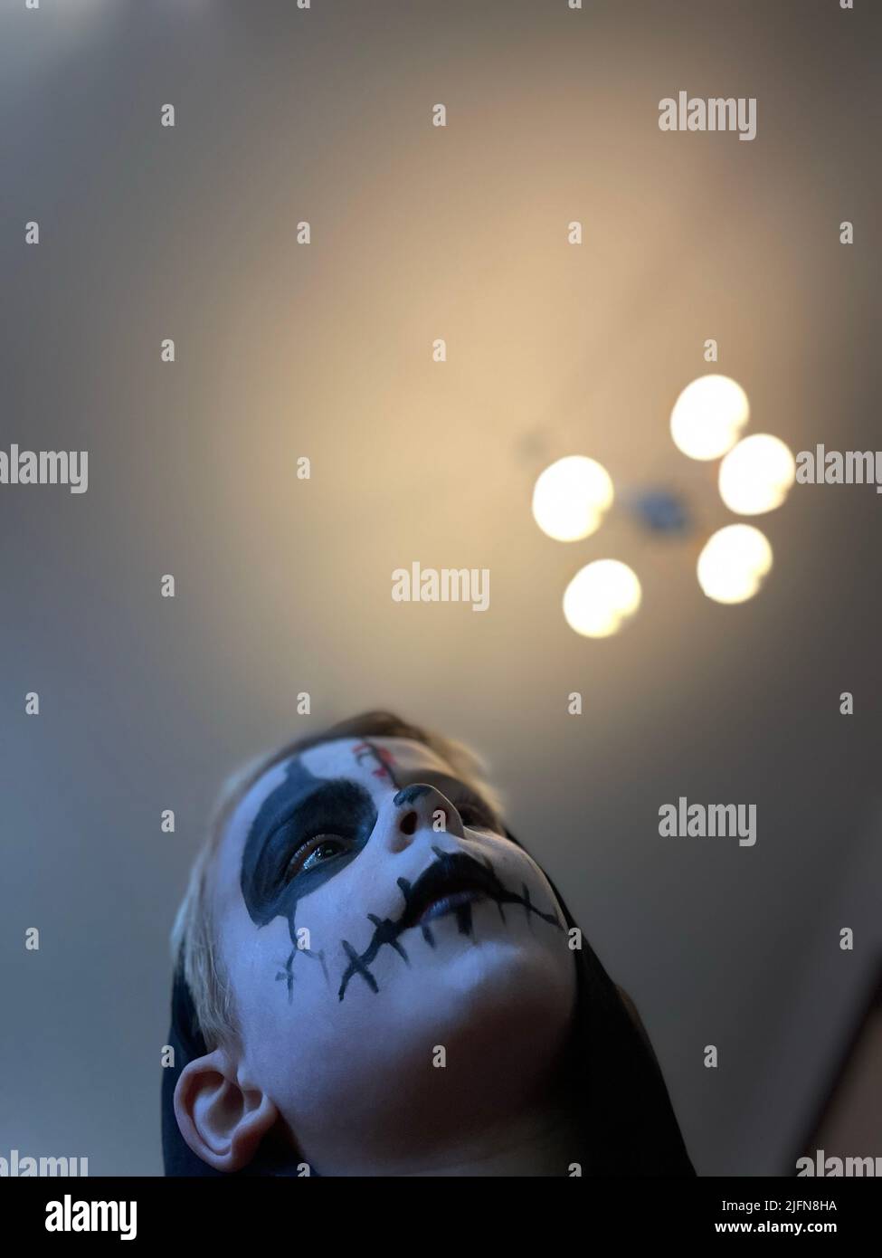 A vertical low angle shot of a child with halloween scary makeup Stock ...