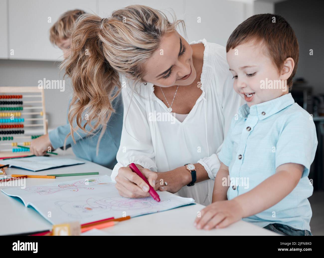 Family learning together at home. Mother helping son with homework ...