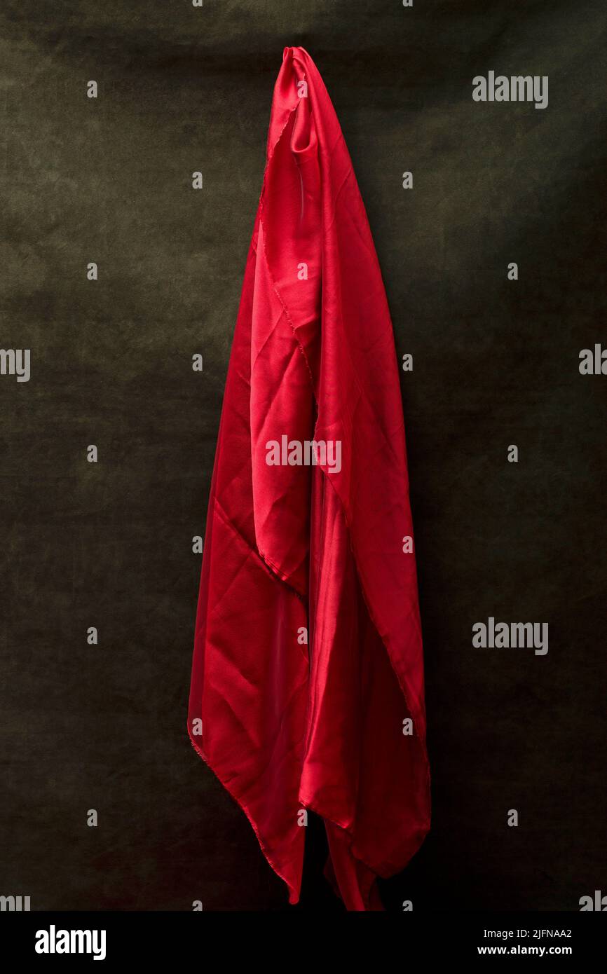 A bright red handkerchief hangs on a green background Stock Photo - Alamy