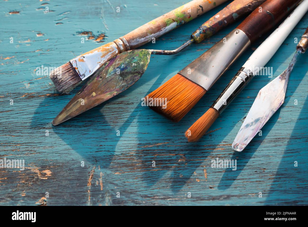 Artistic art supply utensils with paintbrushes on turquoise wooden ...