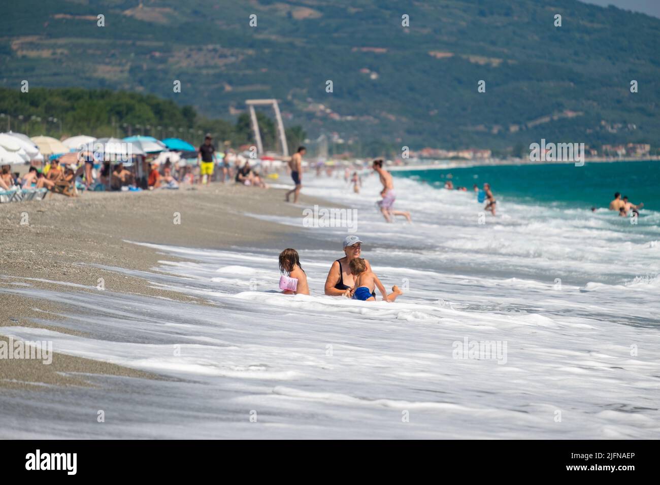 People having fun with the waves in the beach Stock Photo - Alamy