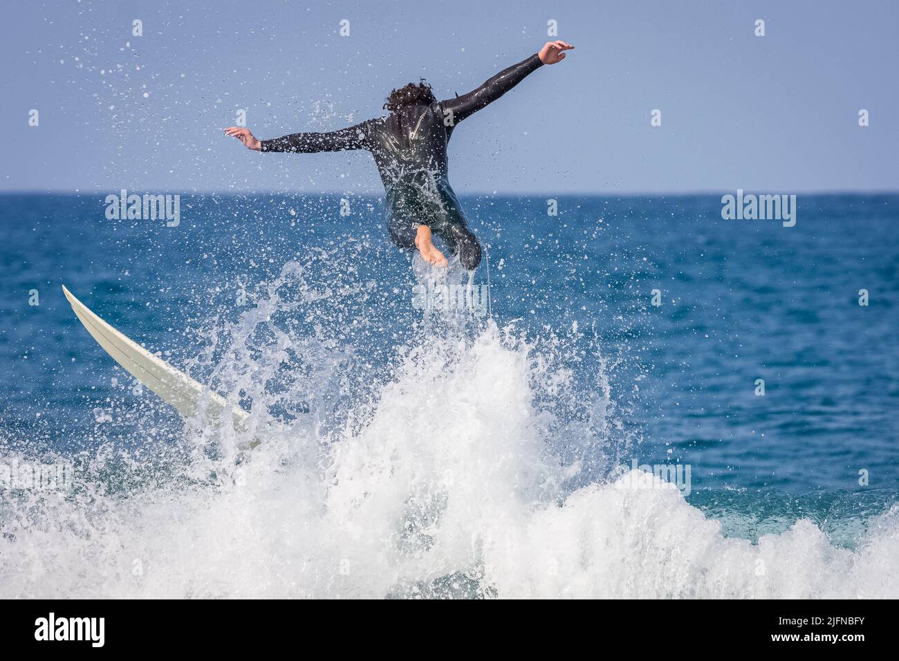 A surfer riding a point break waves and being wipeout in Jeffreys Bay ...