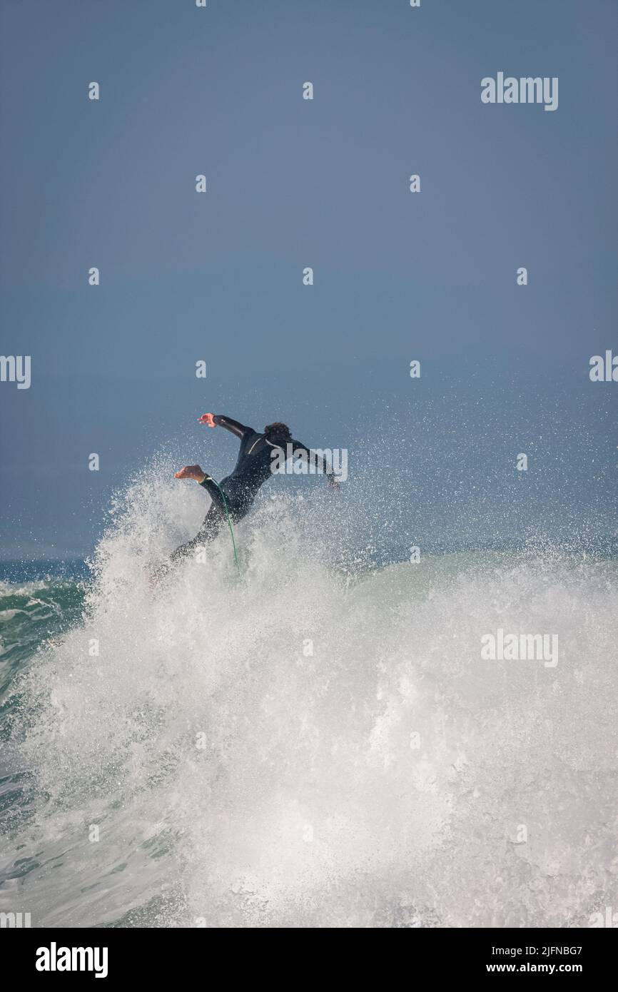 A surfer riding a point break waves and being wipeout in Jeffreys Bay ...