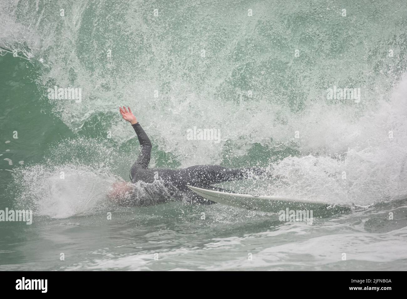A surfer riding a point break waves and being wipeout in Jeffreys Bay ...