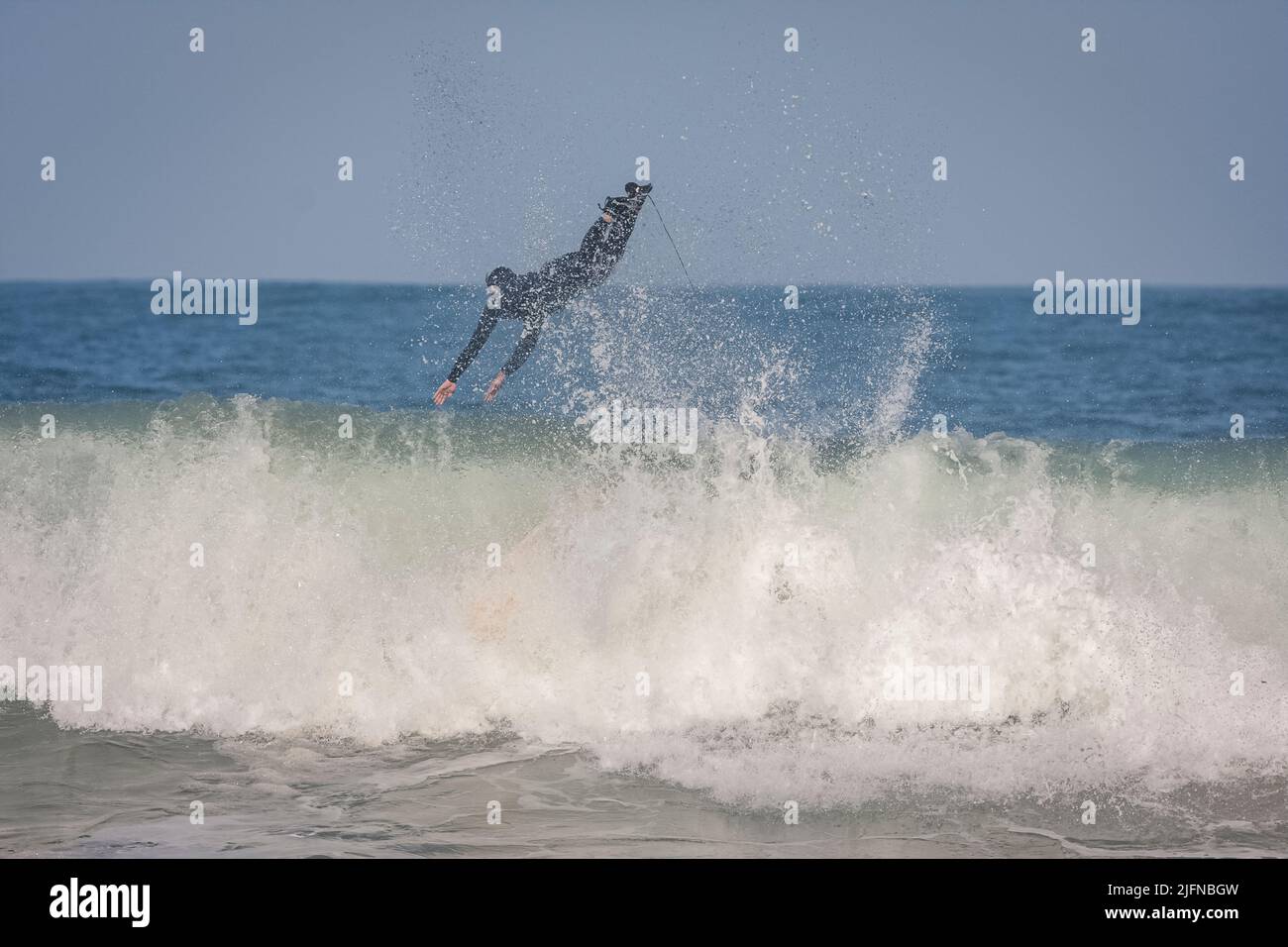 A surfer riding a point break waves and being wipeout in Jeffreys Bay ...