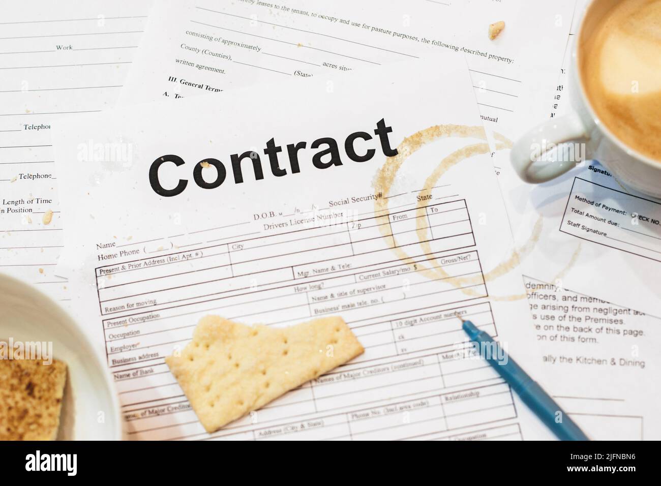 Contract papers with cracker and coffee trace Stock Photo - Alamy