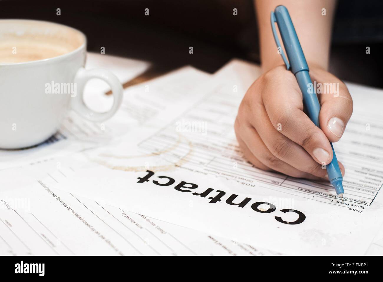 Hand signing dirty contract papers Stock Photo - Alamy