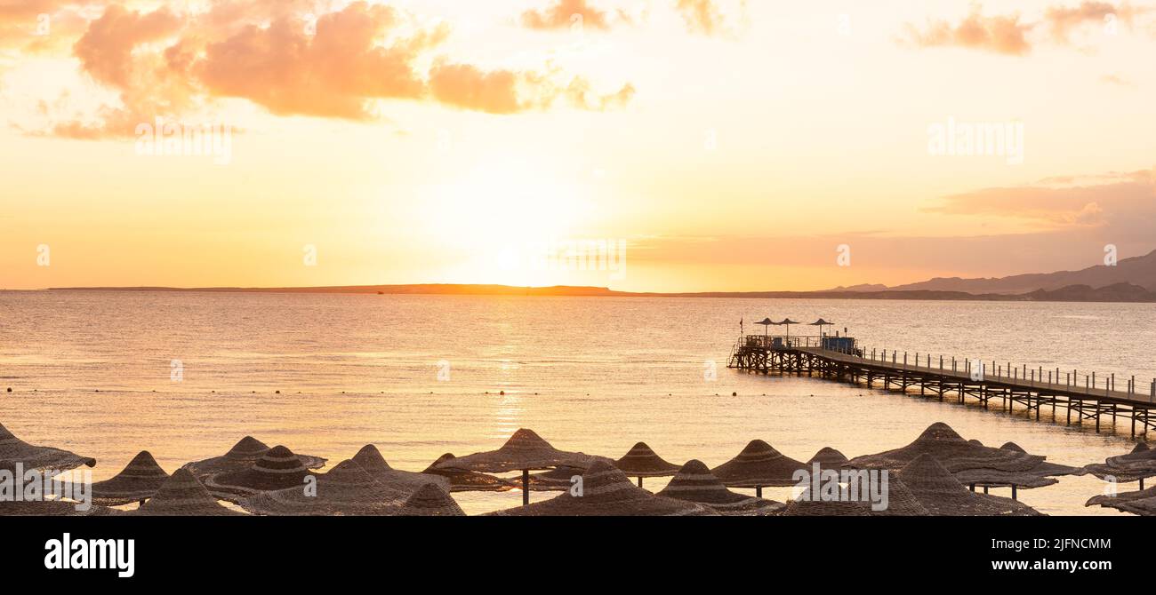 Straw beach rattan umbrellas at the beach Stock Photo - Alamy