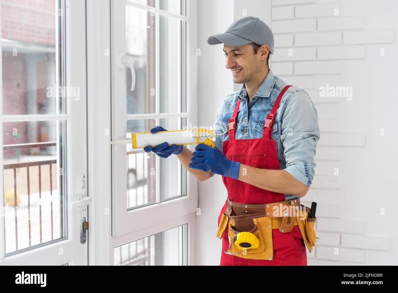 Construction worker installing window in house. Handyman fixing the ...