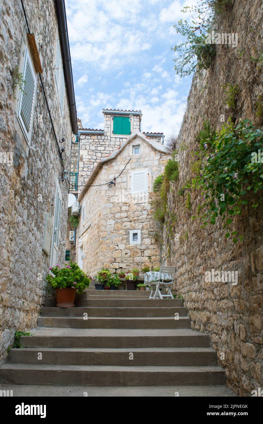 Narrow street with old stone houses in Hvar town, Croatia ...