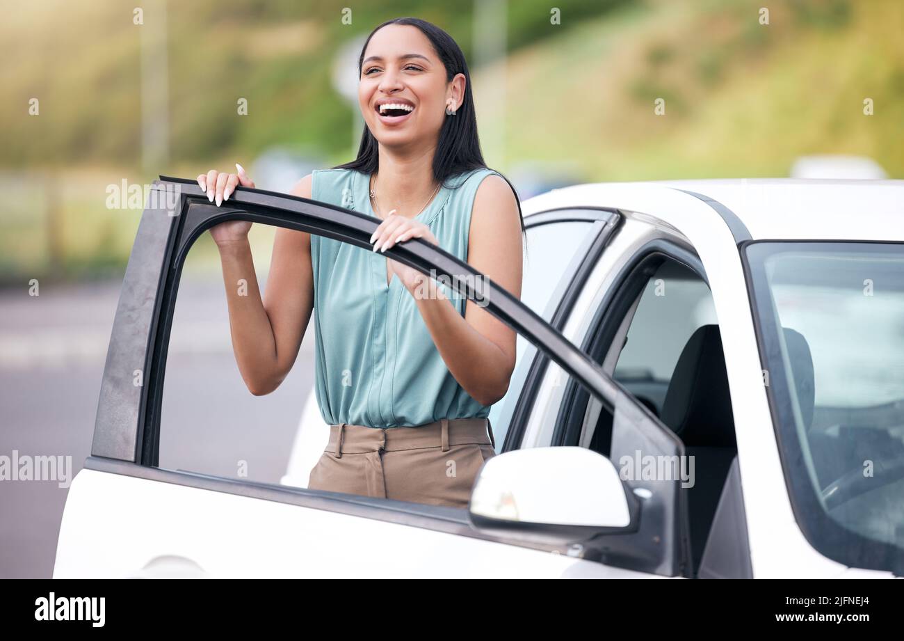 Cheerful mixed race woman driving her new car. Hispanic woman looking ...
