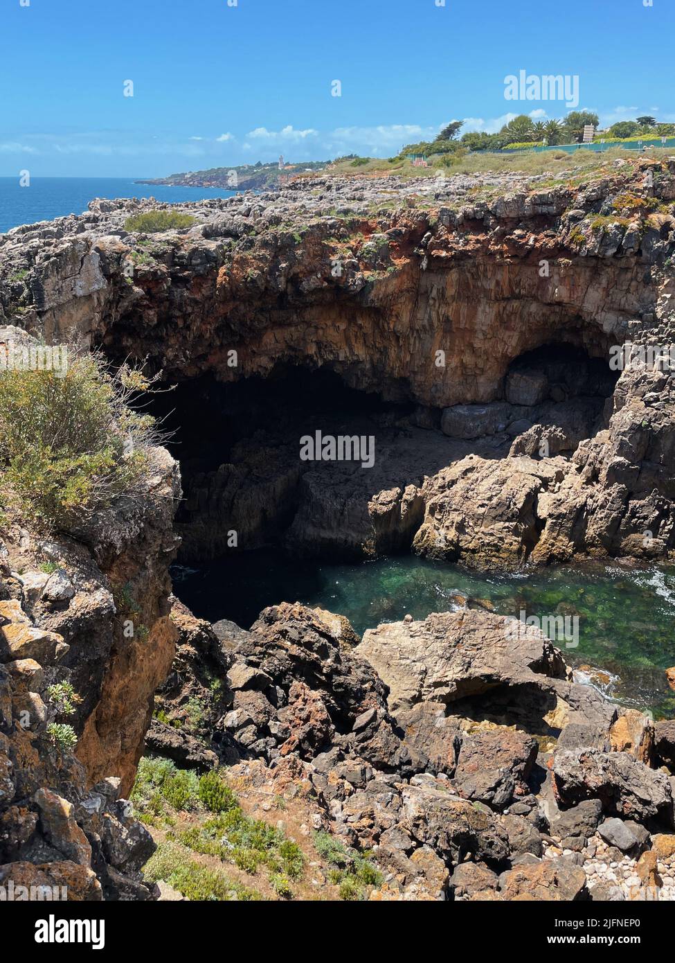 Big cave with water near a coast Stock Photo - Alamy