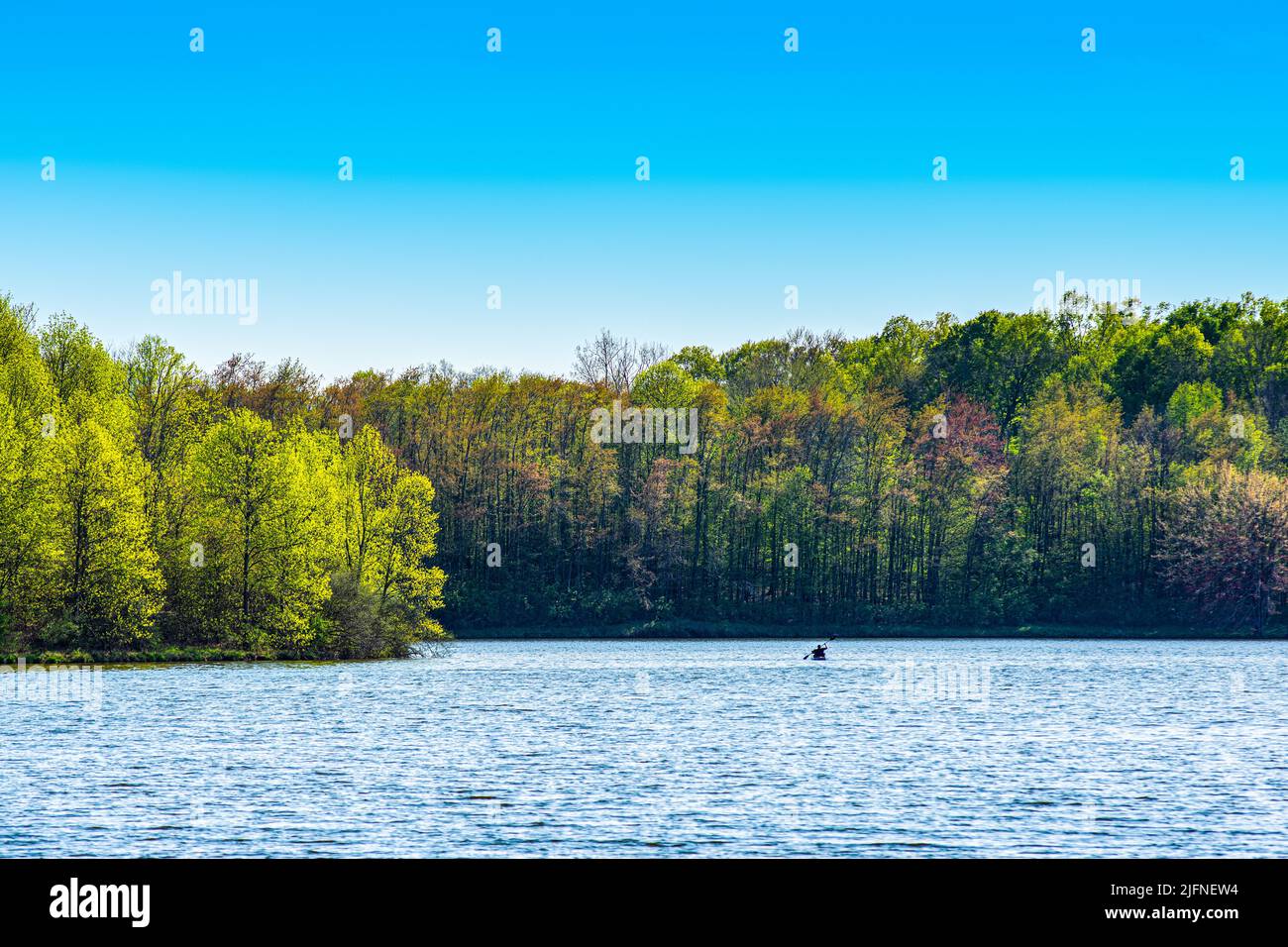 A lone kayaker paddles across the waters of Worster Lake at Potato ...