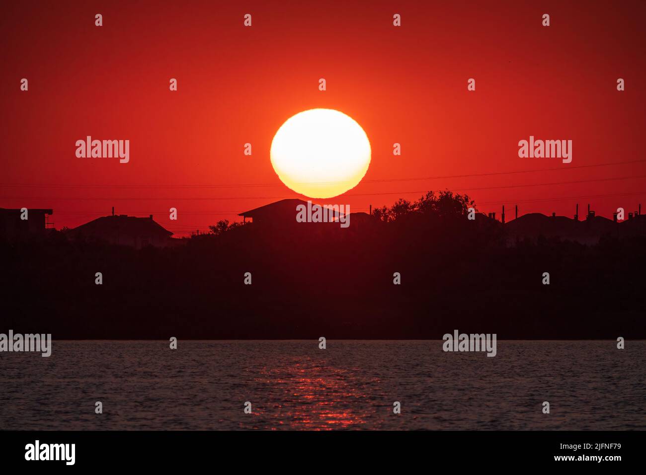 The sun goes down over a lake. Dramatic Sunset Sky Stock Photo - Alamy