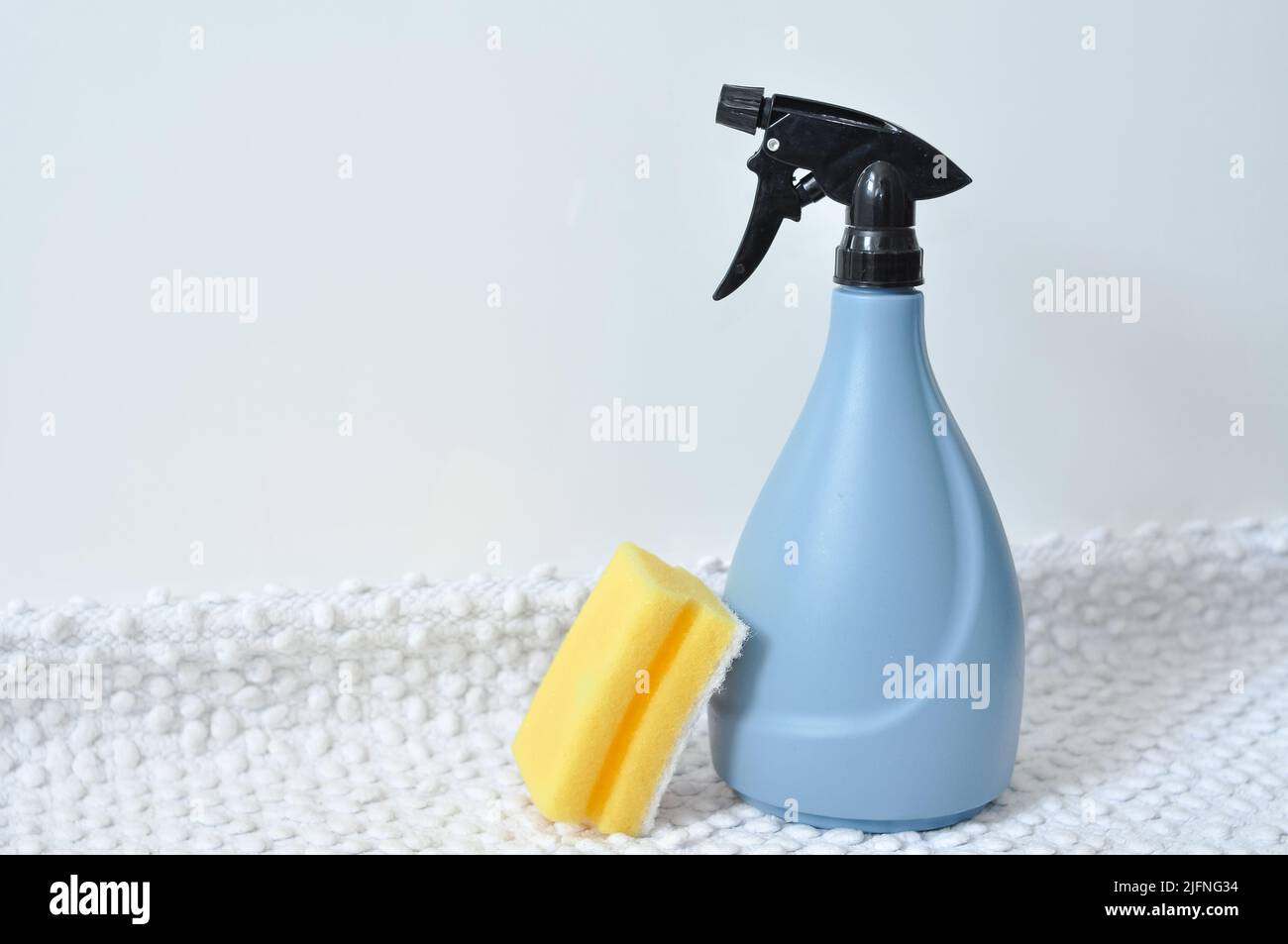blue bottle of spray for cleaning windows and surfaces and a rag ...