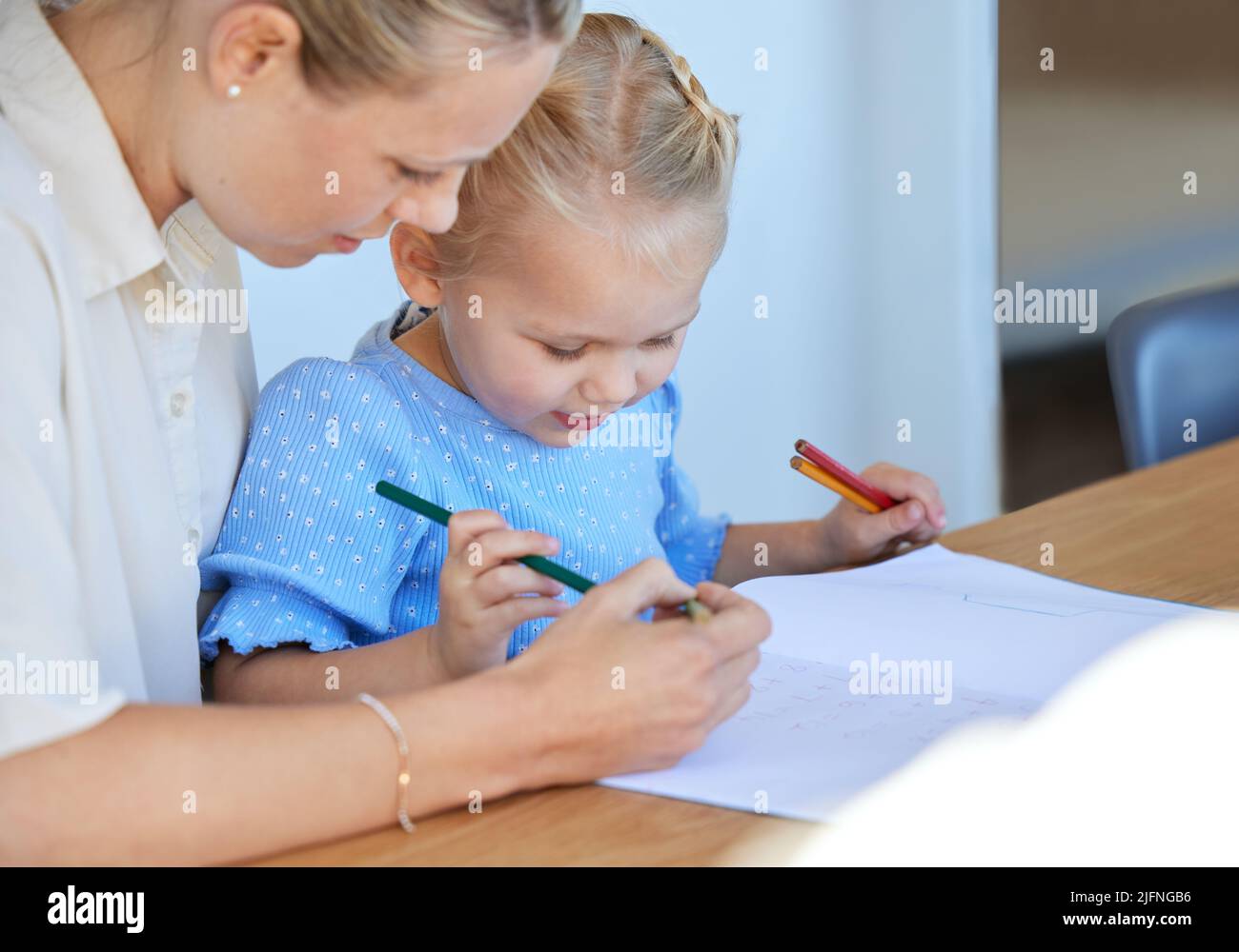 Mother teaching little daughter during homeschool class at home. Cute ...